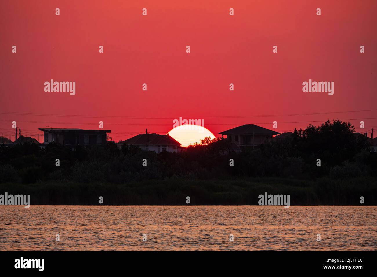 The sun goes down over a lake. Dramatic Sunset Sky Stock Photo - Alamy