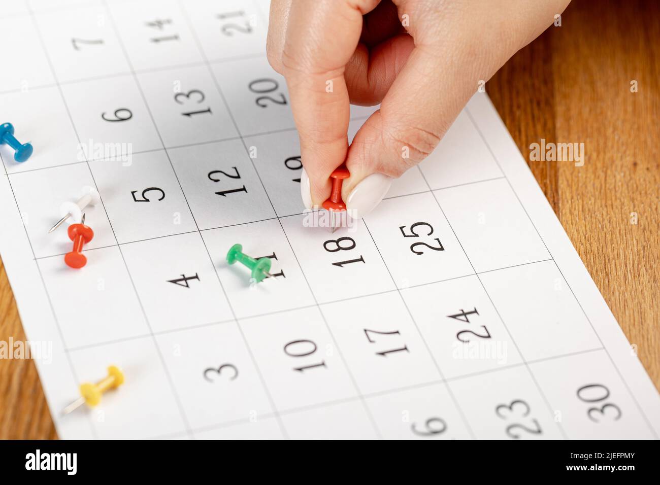 red Hand pin stuck on the day of the month in the calendar, business ...