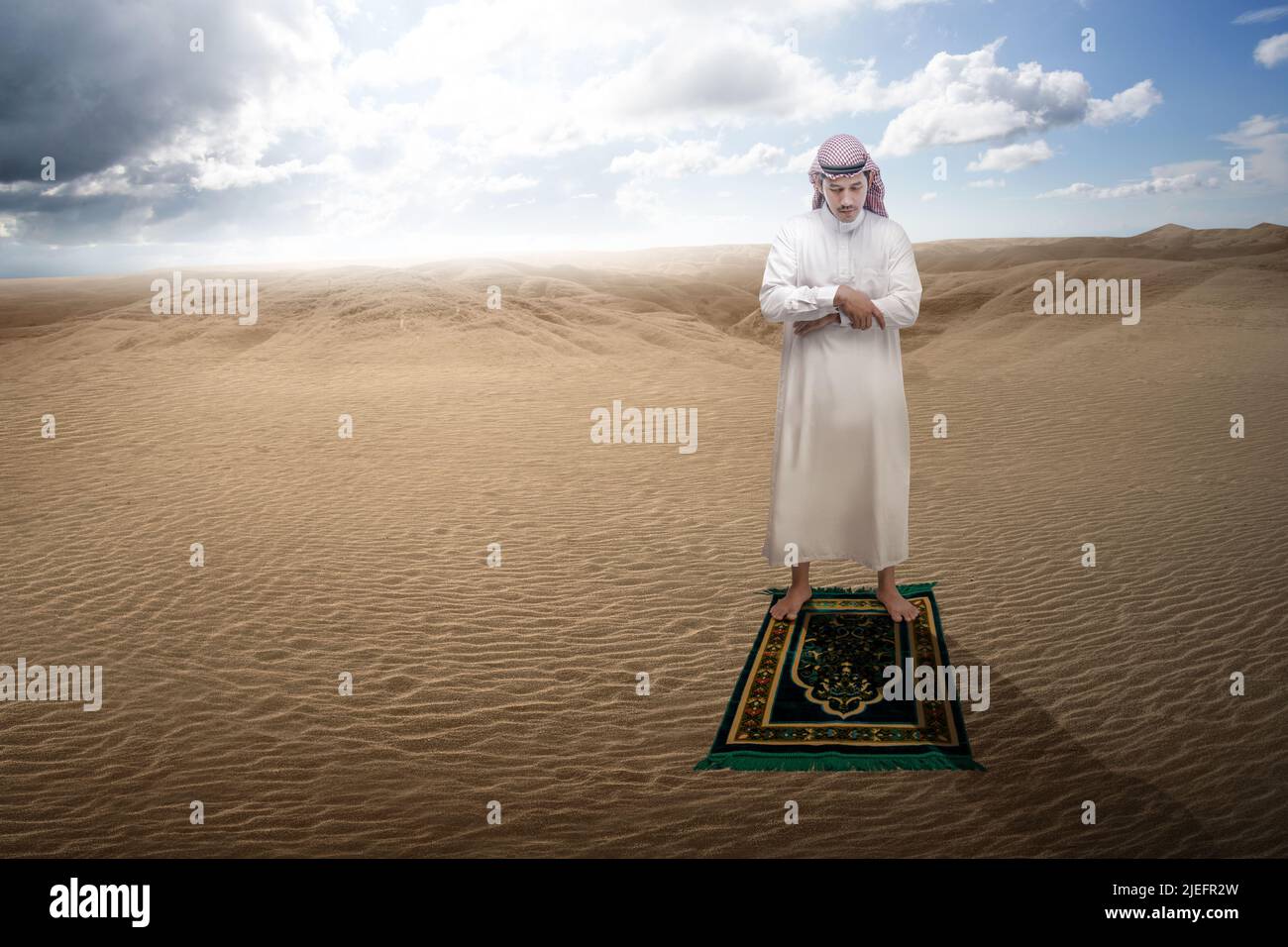 Muslim man with keffiyeh with agal in praying position (salat) on the ...