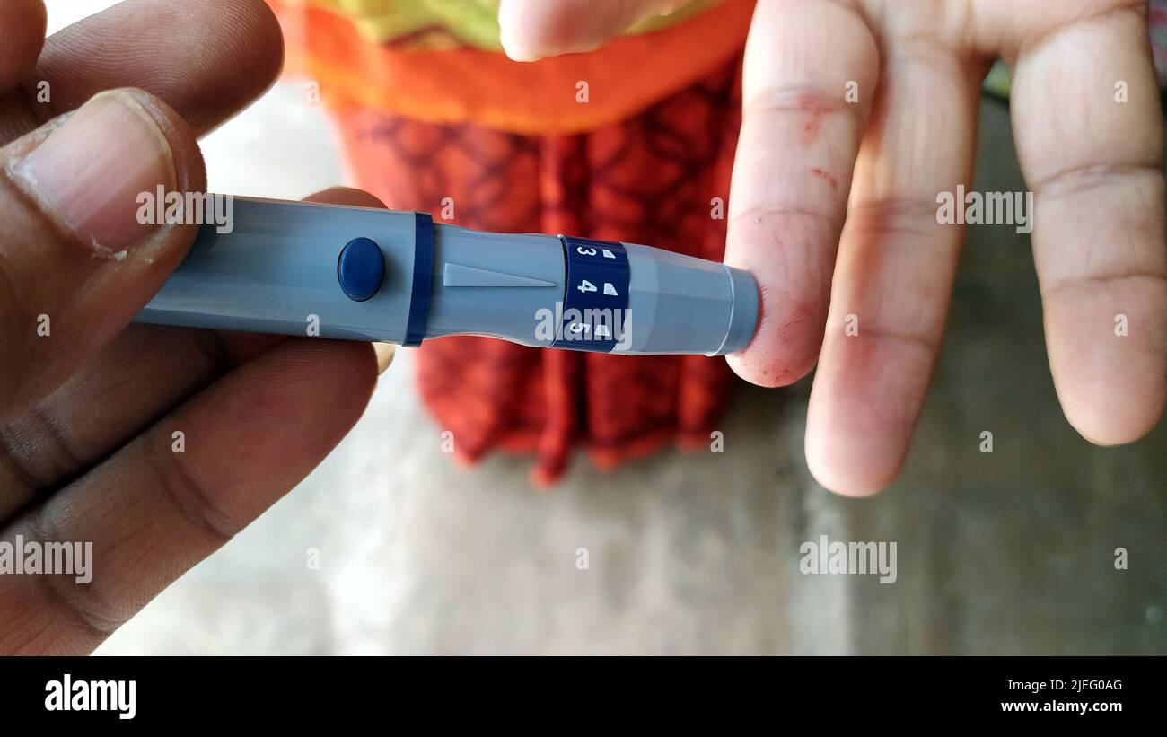 Diabetes machine in hand prick finger to make punctures to obtain small ...
