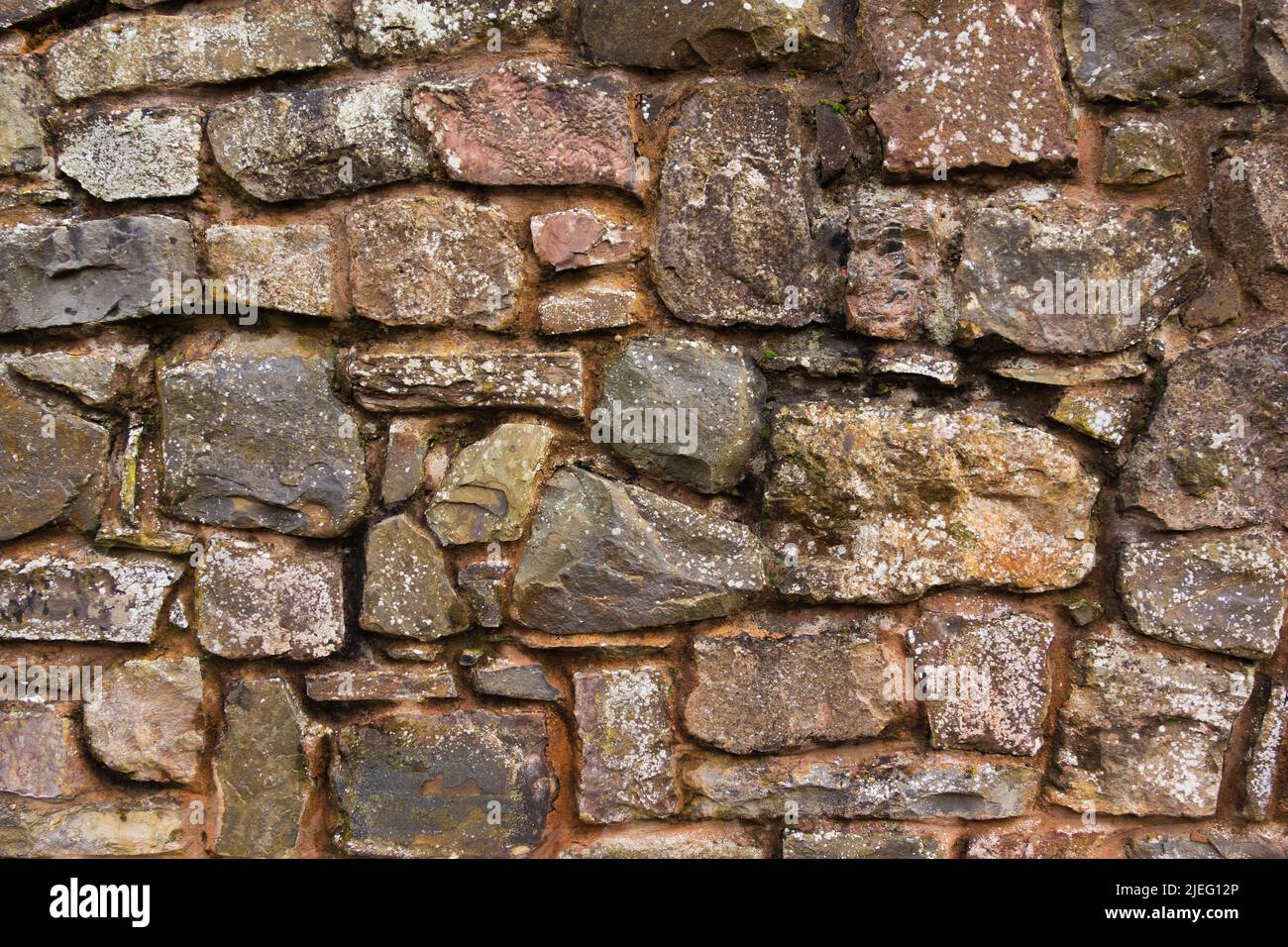 textured traditional stone wall with red mortar Stock Photo - Alamy