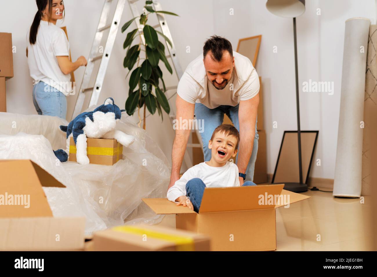Parents and son packing boxes and moving into a new home Stock Photo ...