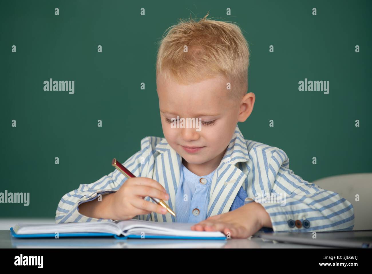 Kid writing in class. School boy studying math on lesson in classroom ...