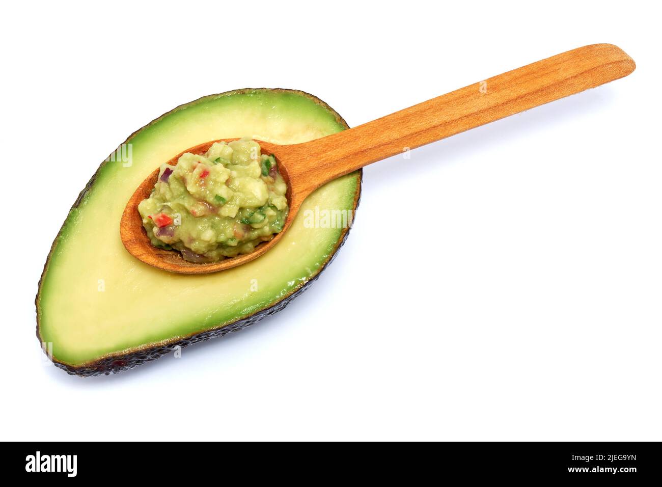 Wooden spoon of guacamole dip sauce and half of avocado isolated on ...