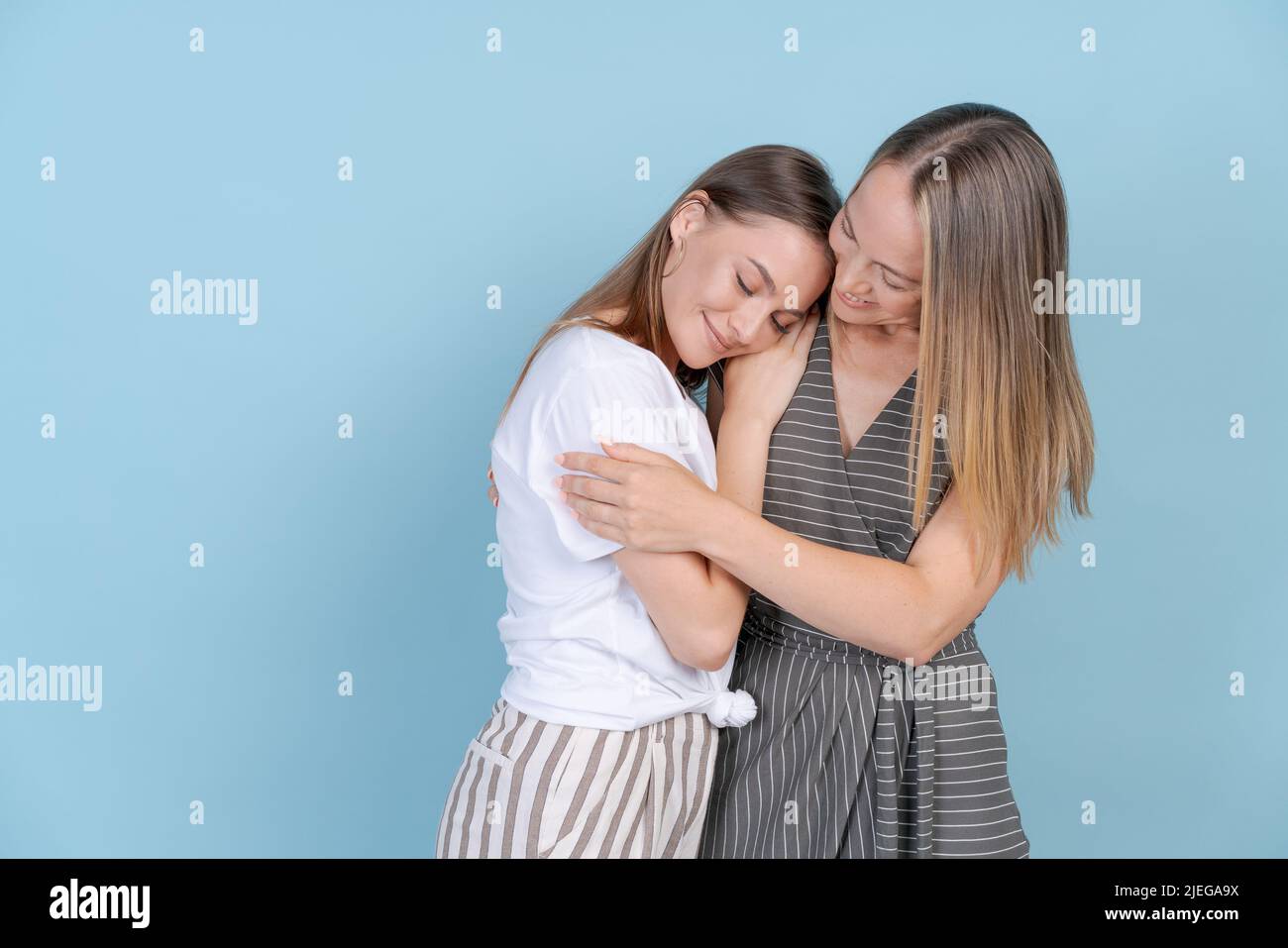 Laughing mature mother hugging happy millennial daughter while spending ...