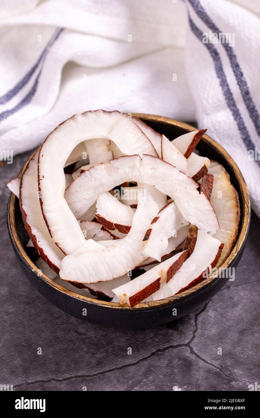 Dried coconut slices. Sliced dry coconut on dark background. Sun-dried ...