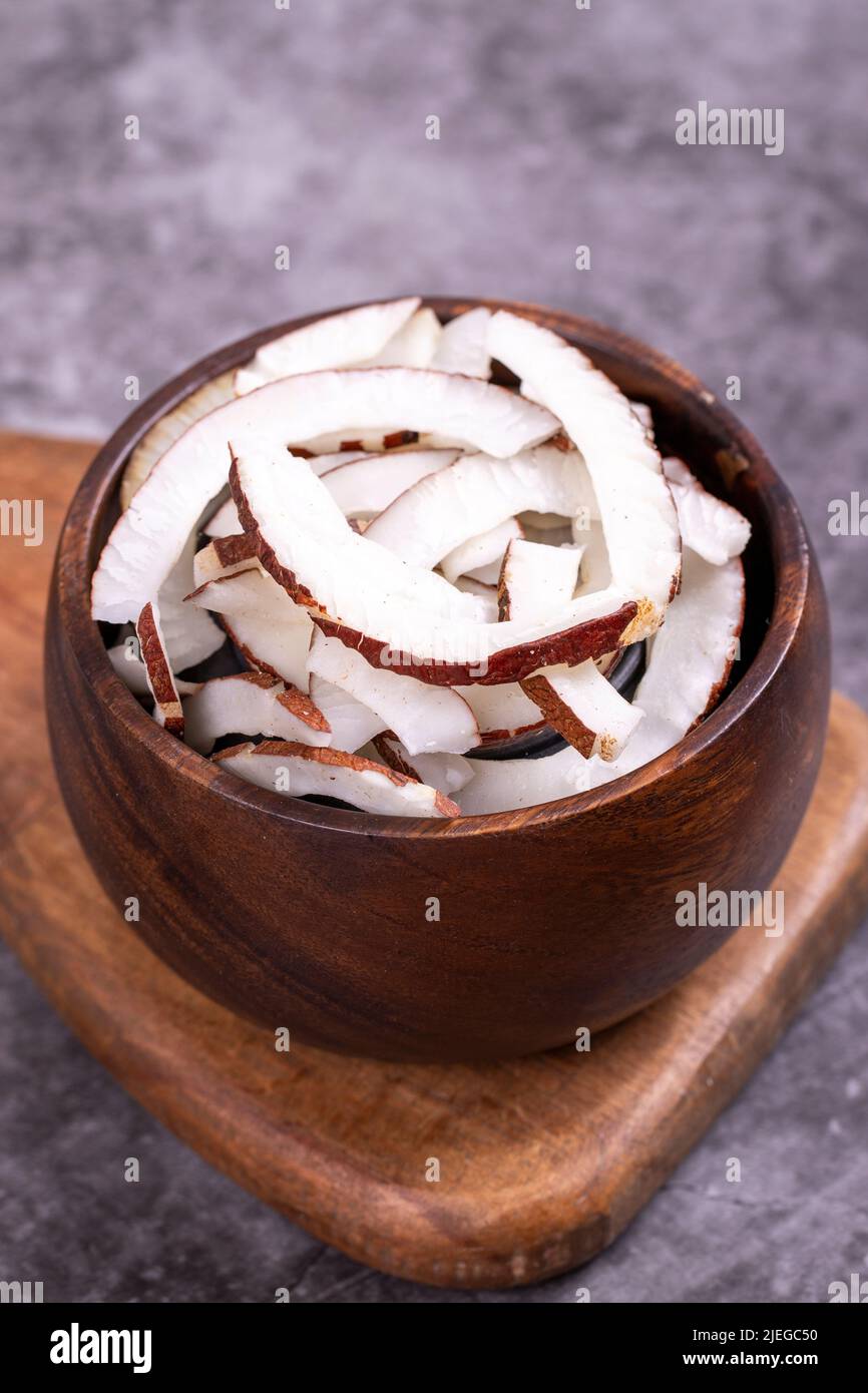 Dried coconut slices. Sliced dry coconut on dark background. Sun-dried ...