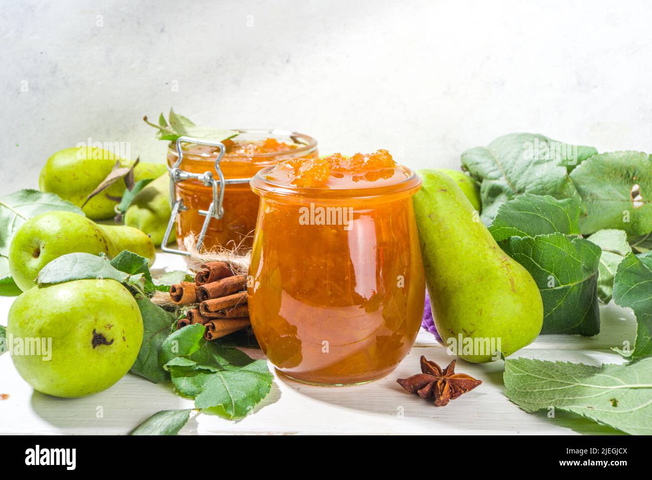 Homemade golden colored pear jam, with farm pears and leaves on white ...