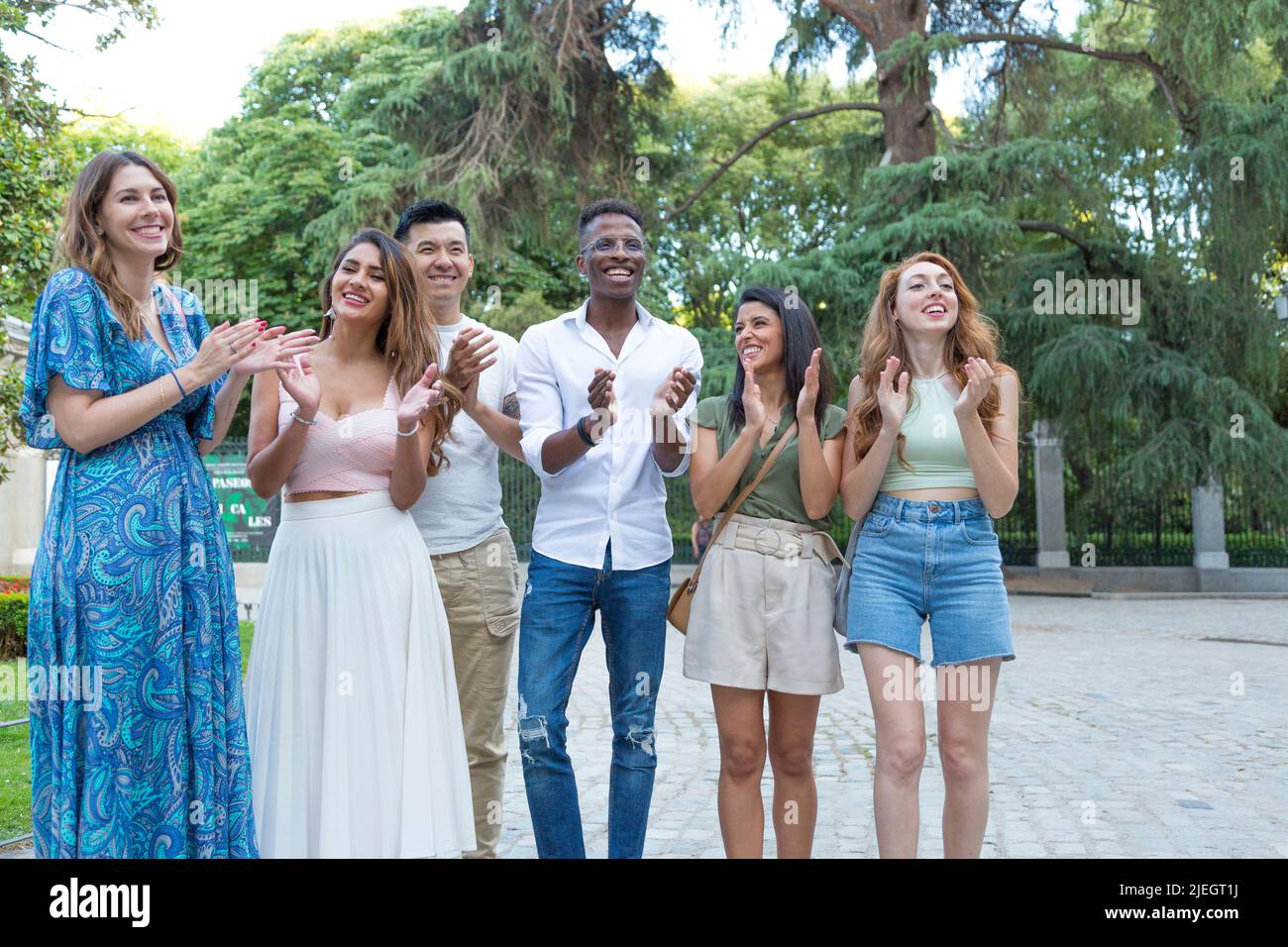 Group of multiethnic friends clapping in a urban park Stock Photo - Alamy
