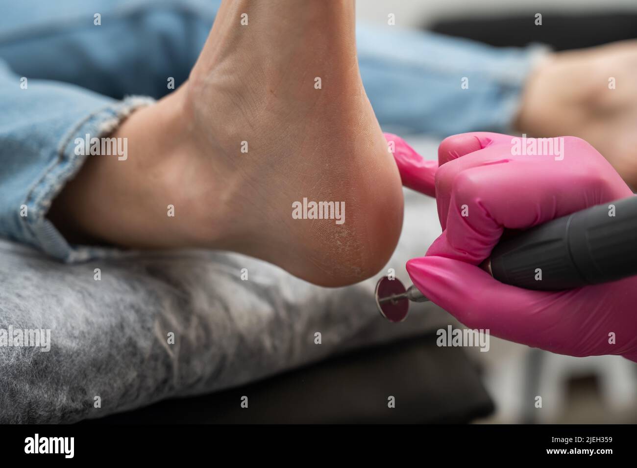 Woman on professional pedicure procedure by abrasive disc machine in ...
