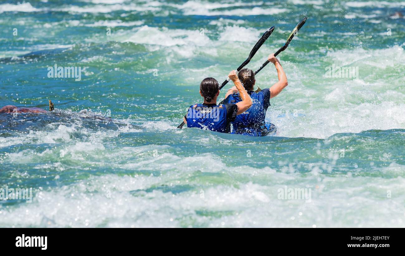 Canoe doubles team race action thrills challenge through water rapids ...