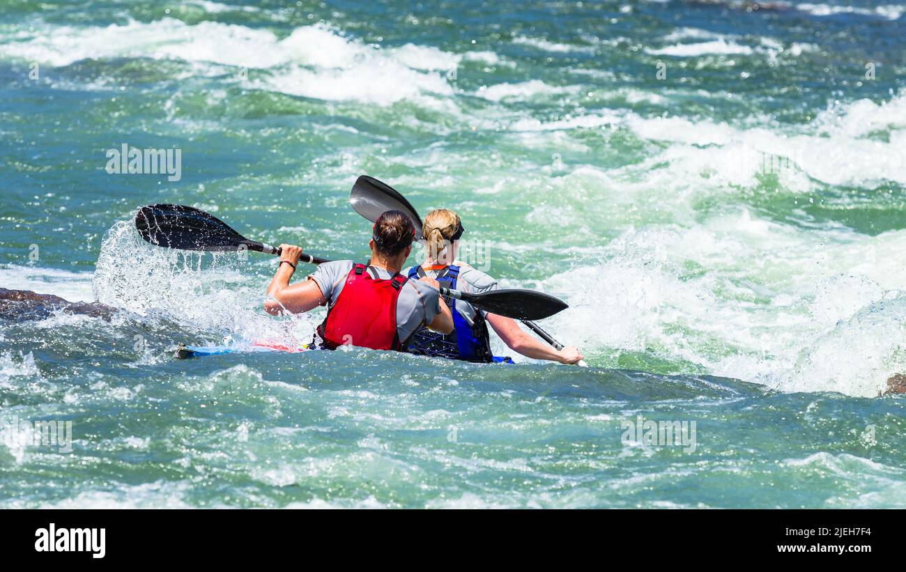Canoe doubles team race action thrills challenge through water rapids ...