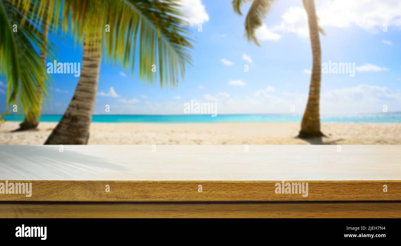 Empty wooden table over blurred sunny tropical beach background ...