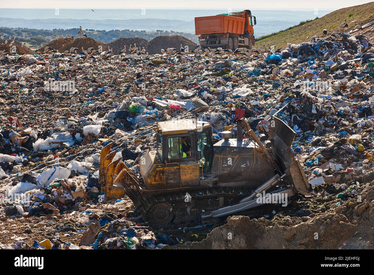 Heavy machinery shredding garbage in an open air landfill. Waste Stock ...