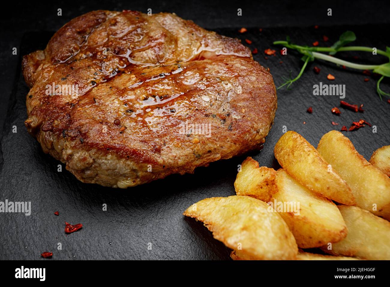Meat steak on black slate with fried potatoes. argentinian Stock Photo ...