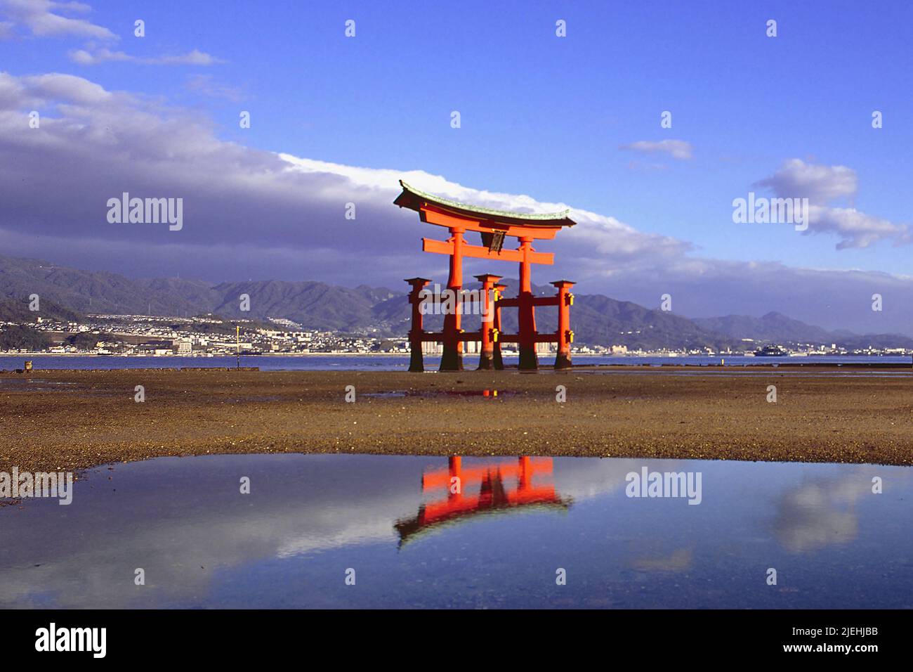 The bright red Sea-gate of Miyajima temple, Japan, against a background ...