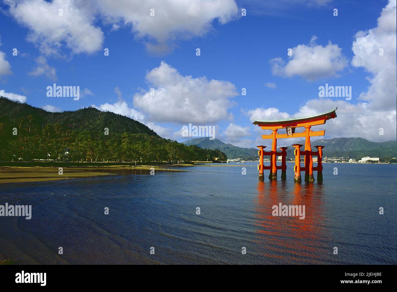 The bright red Sea-gate of Miyajima temple, Japan, against a background ...