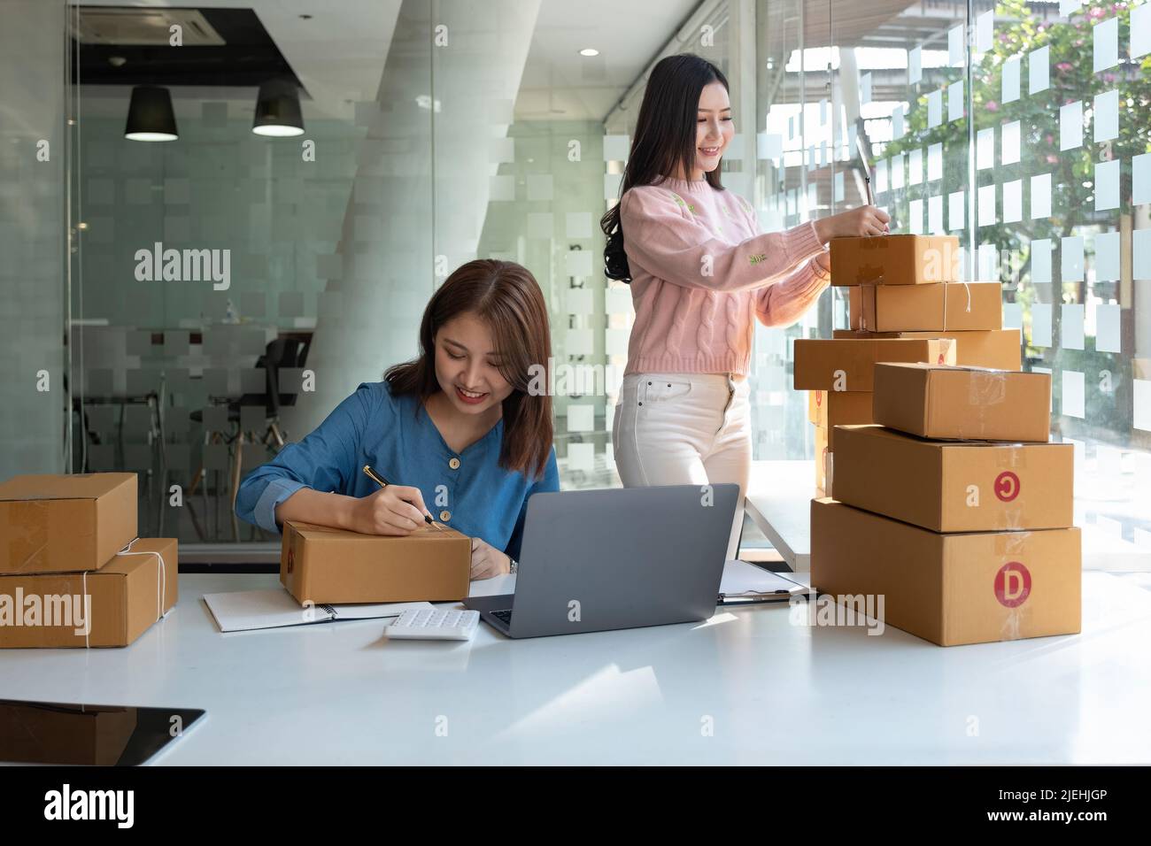 Asian business woman on sofa using a laptop computer checking customer ...