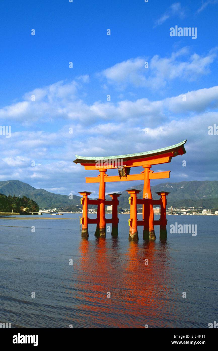The bright red Sea-gate of Miyajima temple, Japan, against a background ...