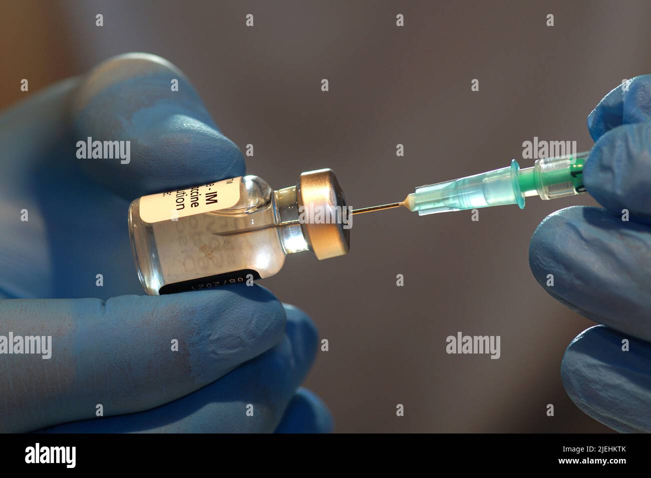 Hand mit Spritze und Corona-Impfstoff von Biontech / Pfizer, Handschuhe ...