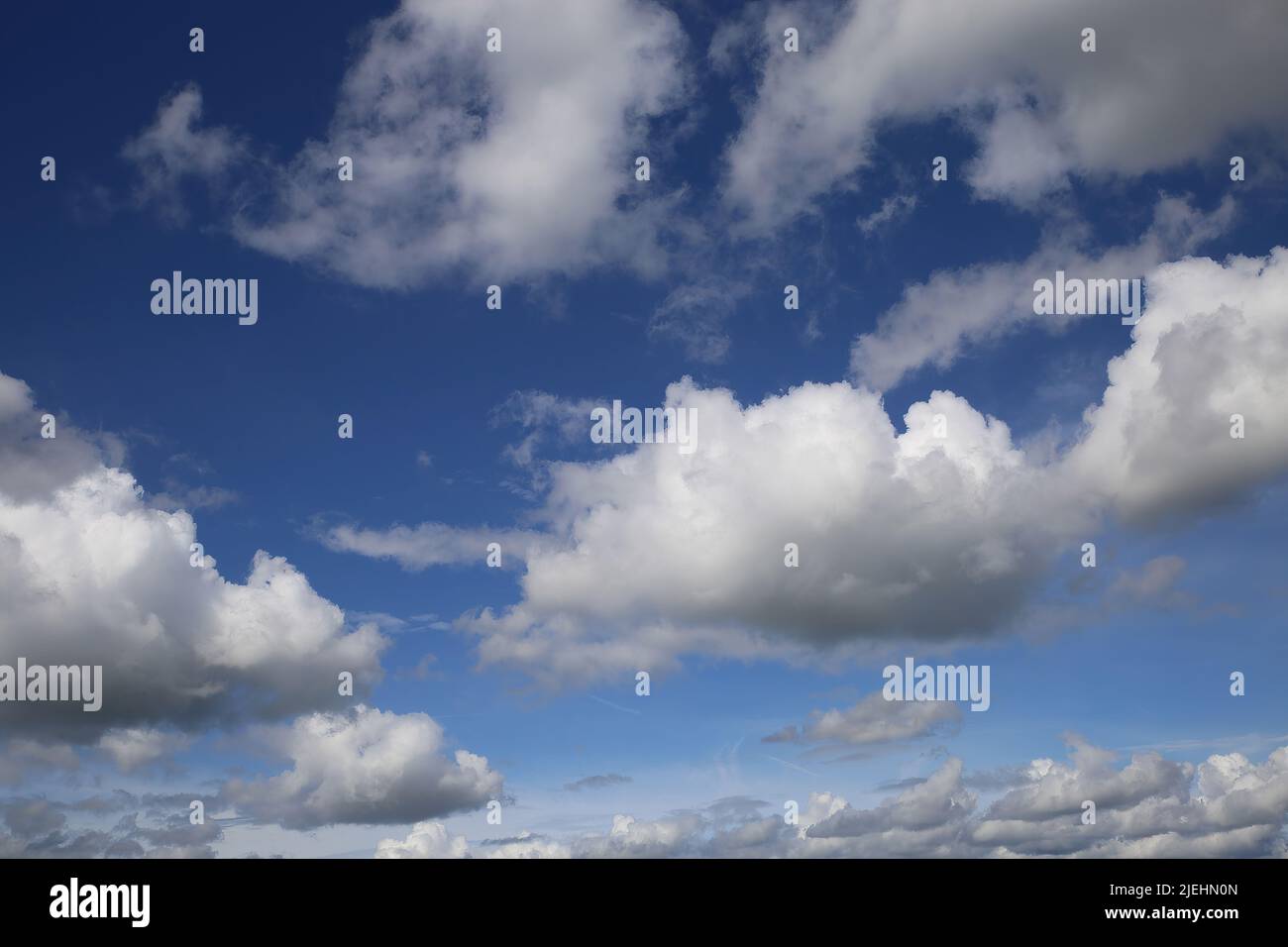 Blue clear summer sky background, high fluffy fine weather summer cumulus clouds, day sunlight ...