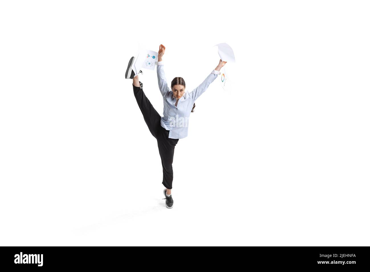 Portrait of female employee, office worker throwing papers in jump ...