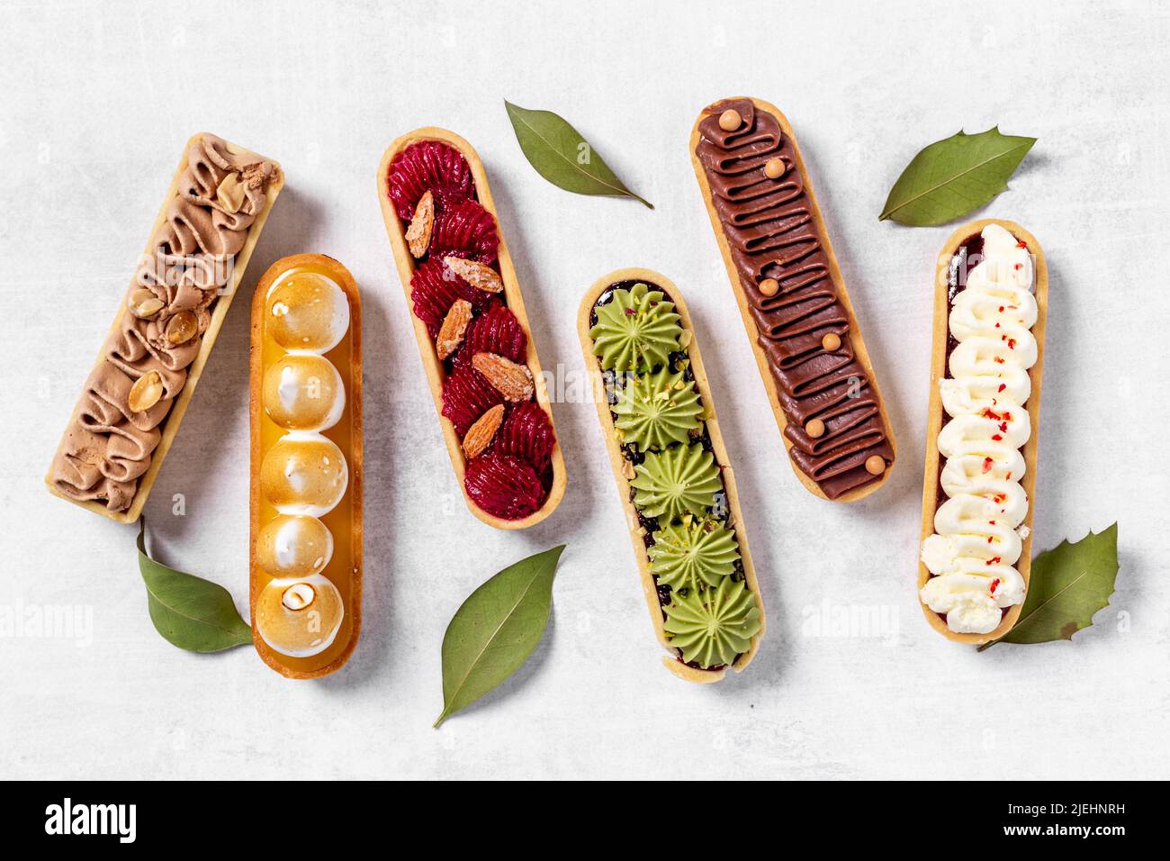 Eclairs with pistachio raspberries and chocolate cream topping Stock ...