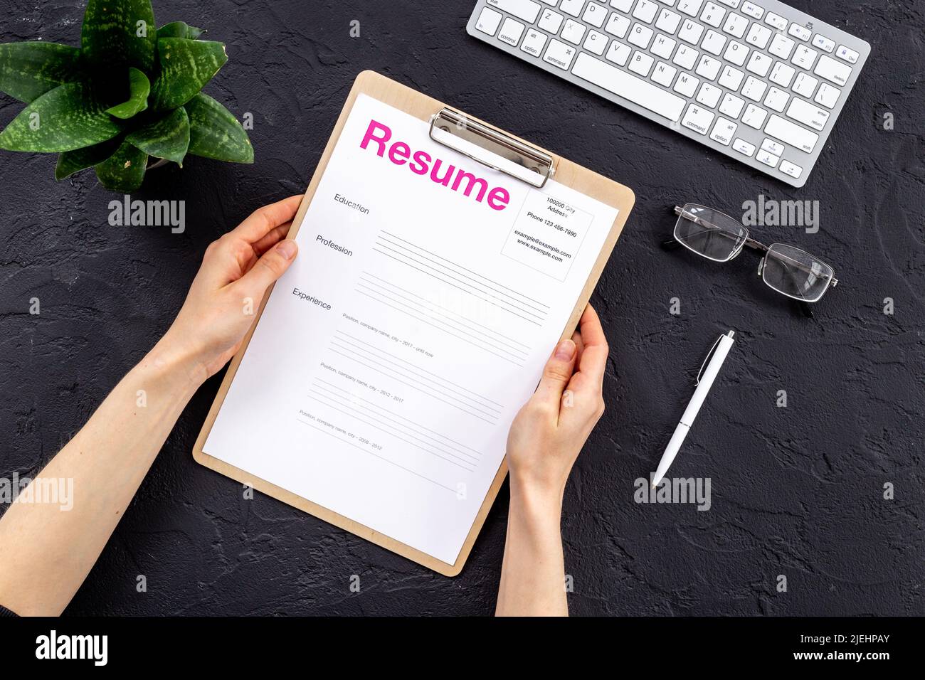 Hands with resume application form on office table. Find new job ...
