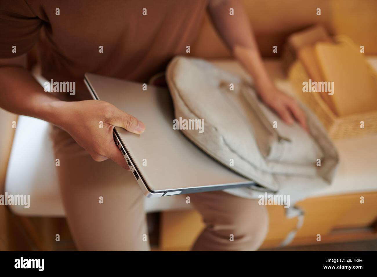 College student putting laptop in backpack when getting ready in the ... College student putting laptop in backpack when getting ready in the ...