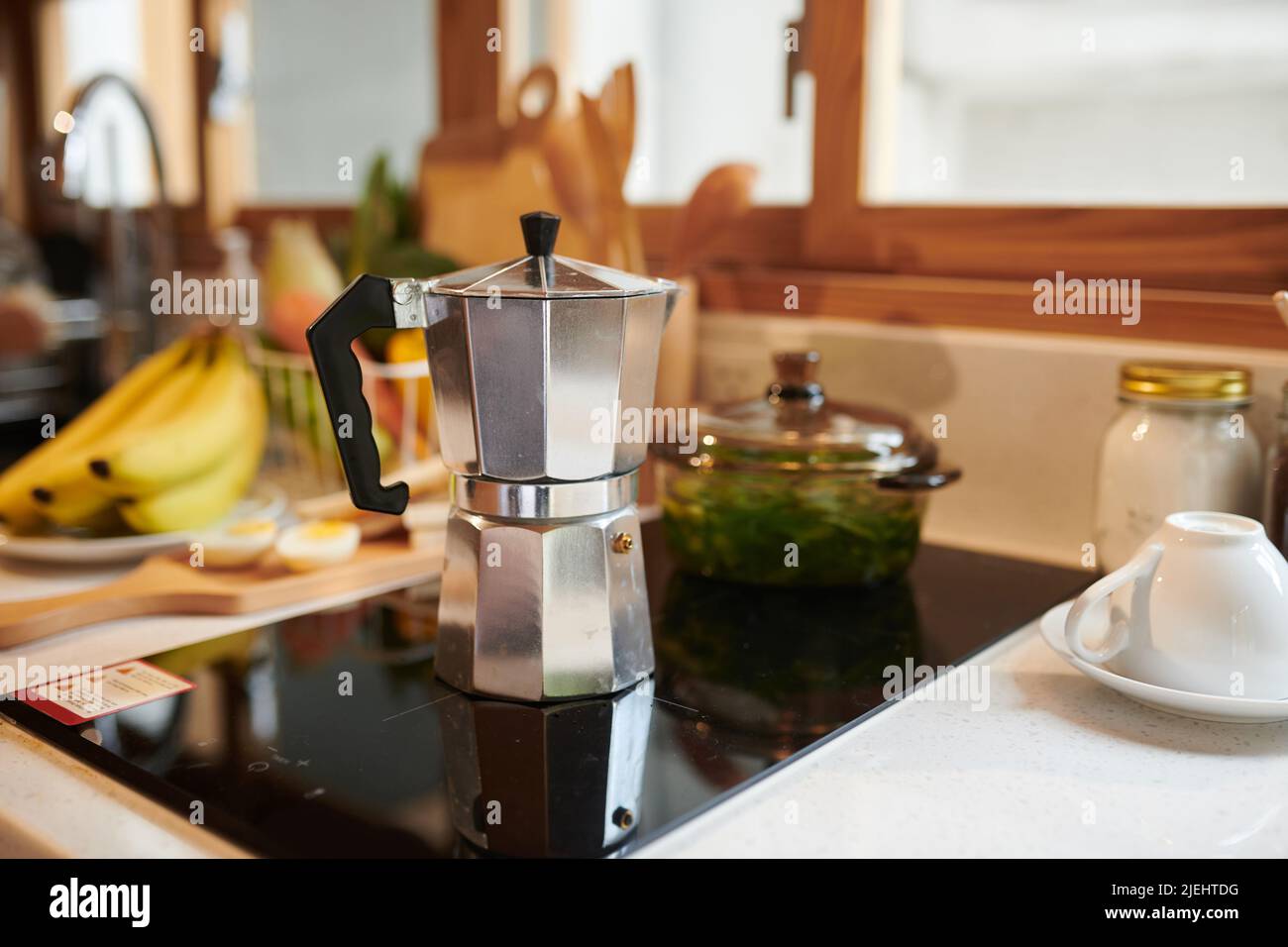 Moka pot on stove in kitchen, morning routine concept Stock Photo - Alamy