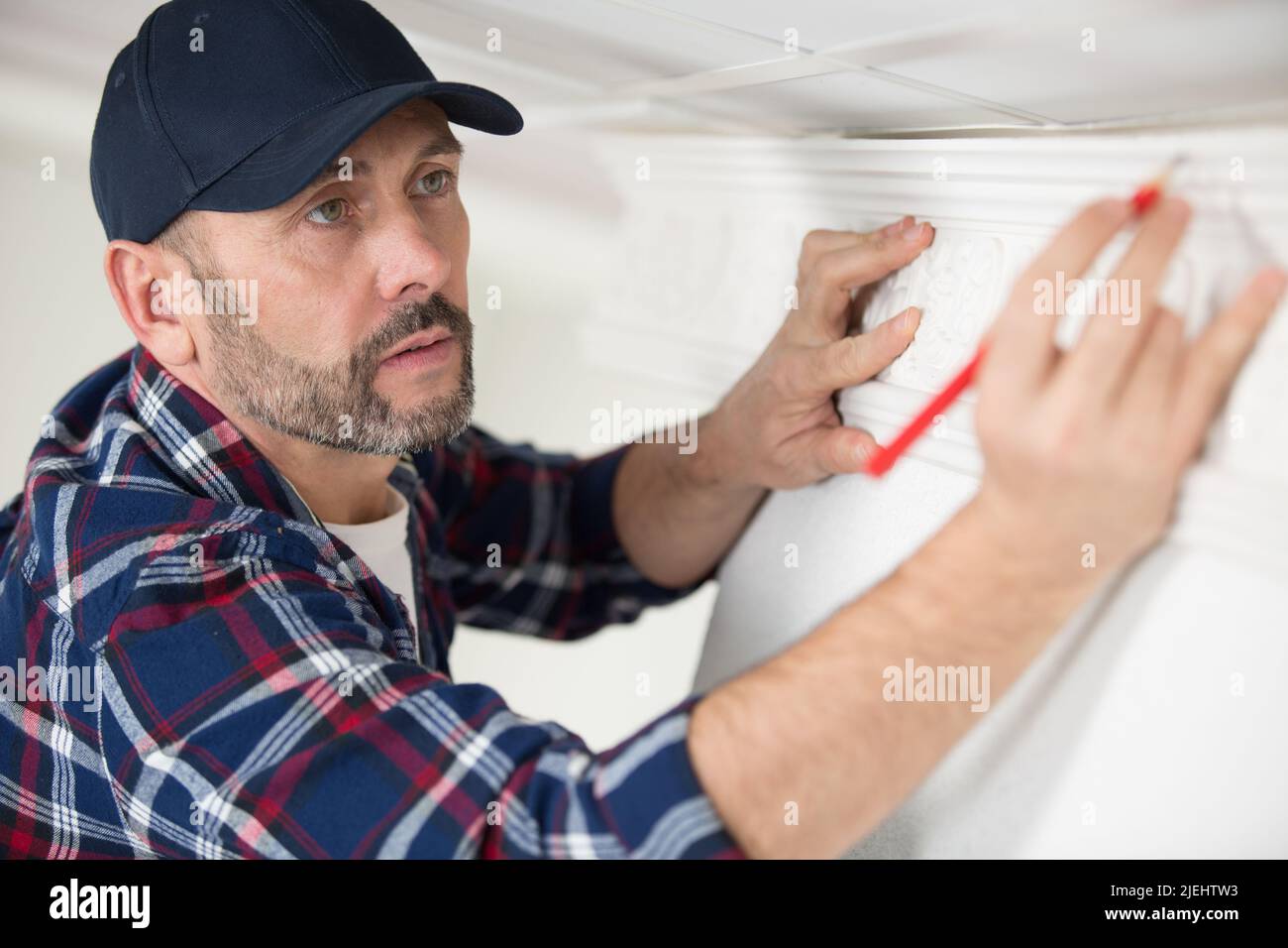 workman or builder marking ceiling with pencil Stock Photo - Alamy