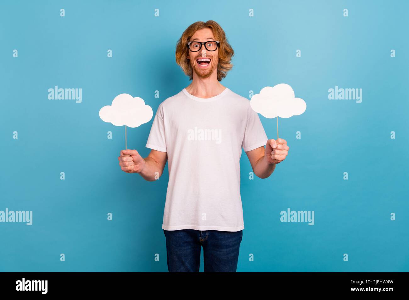 Photo of positive cheerful man hold two cloud paper card stick toothy ...