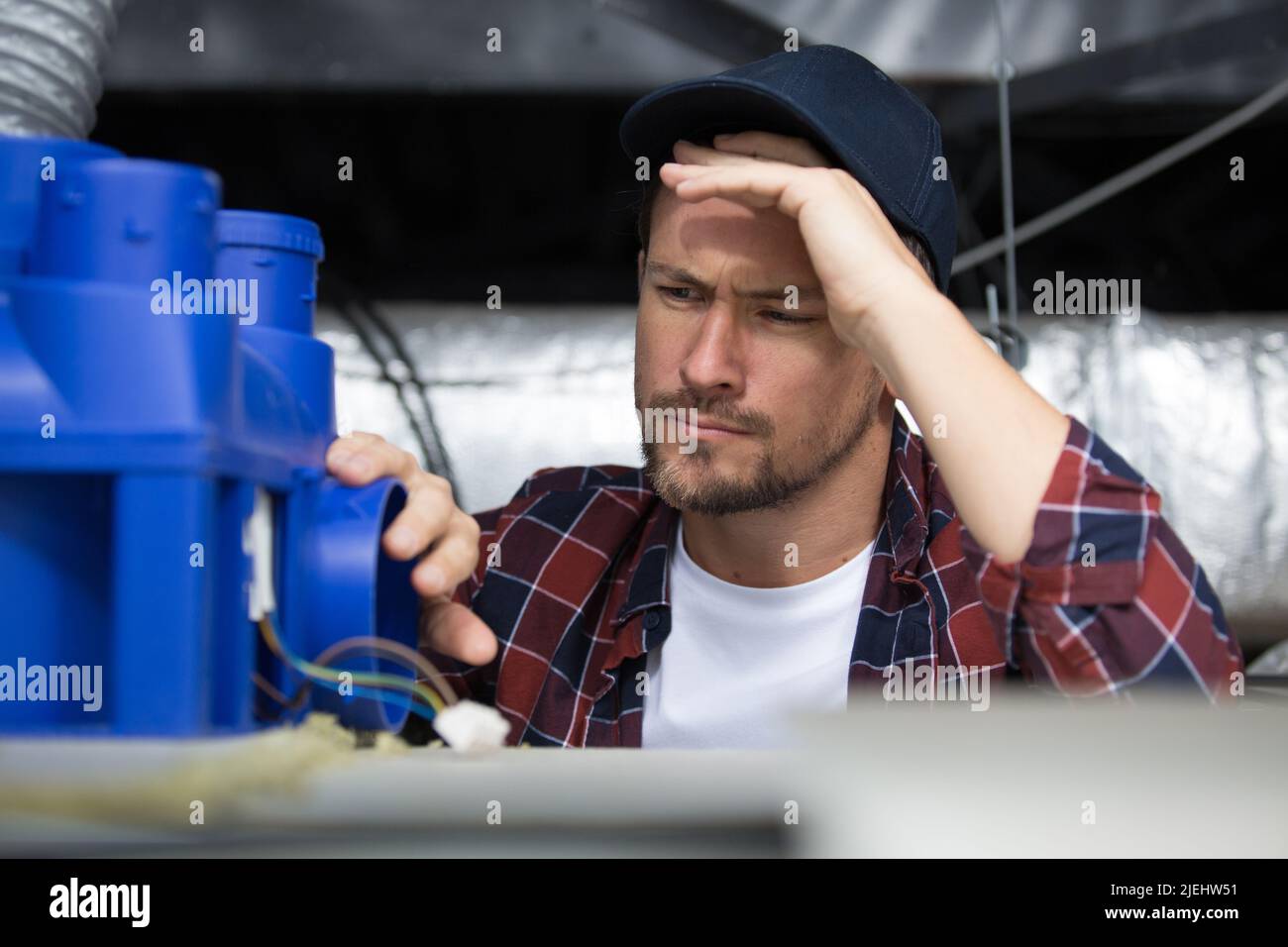 upset worker examines ventilation in the ceiling Stock Photo - Alamy