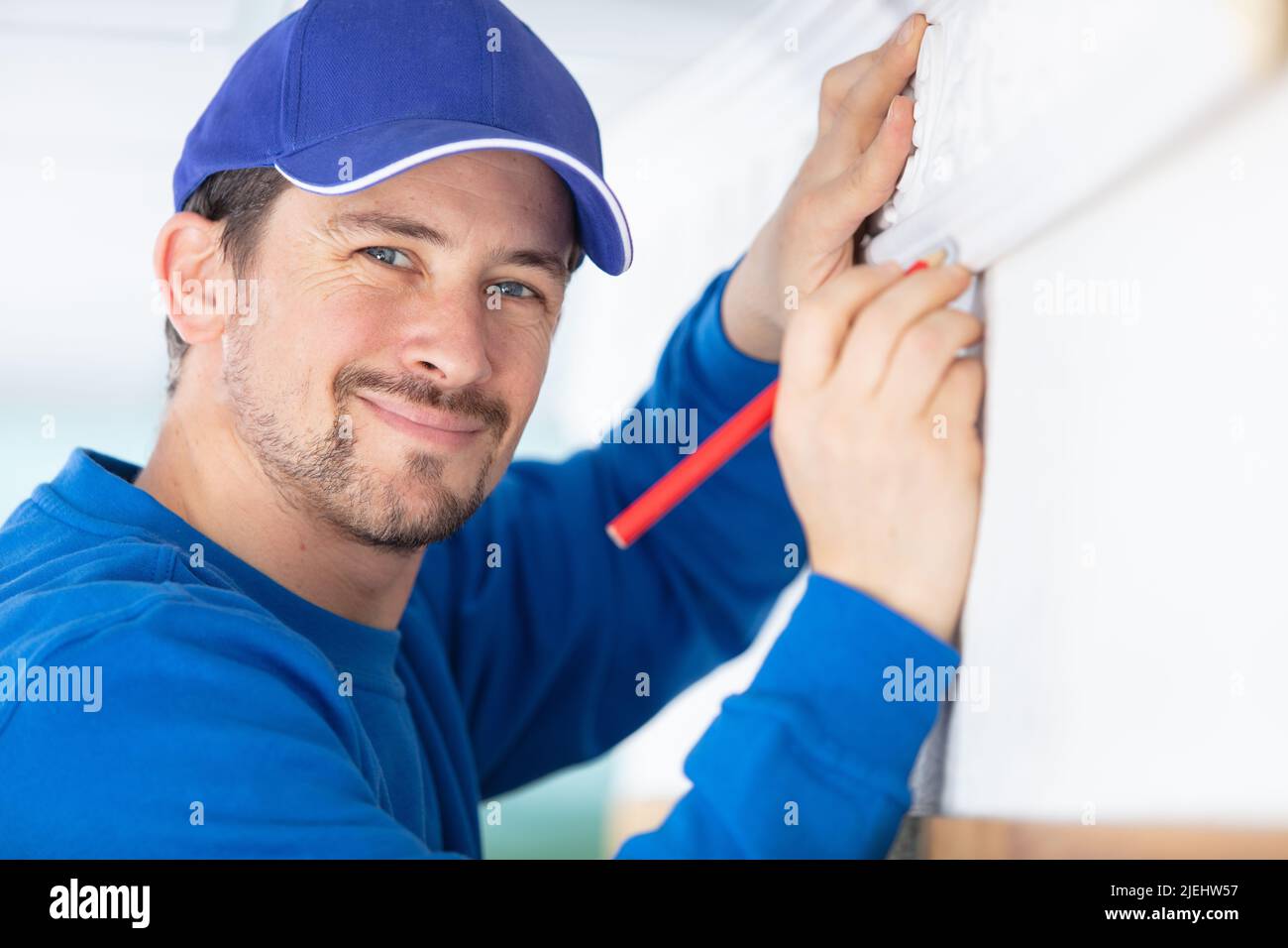 builder marks on the wall with a ruler and pencil Stock Photo - Alamy