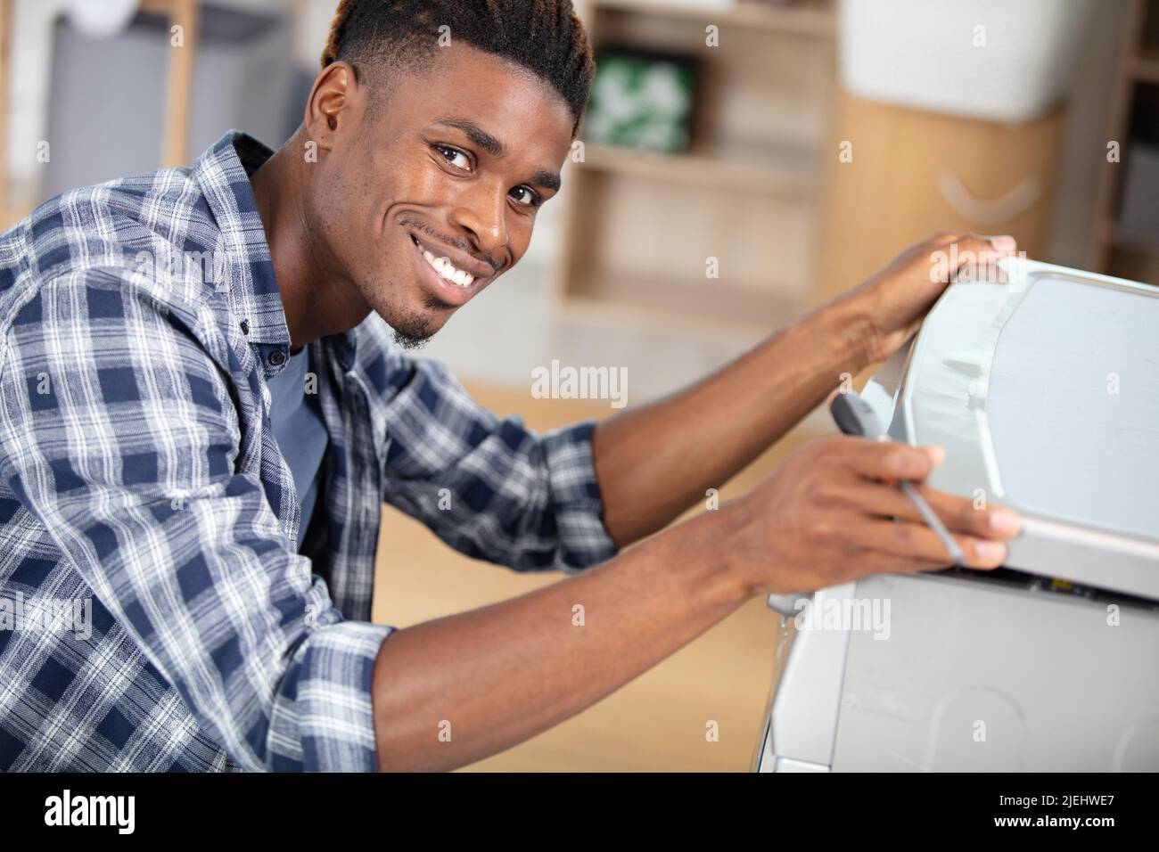 working man plumber repairs a washing machine in laundry Stock Photo ...