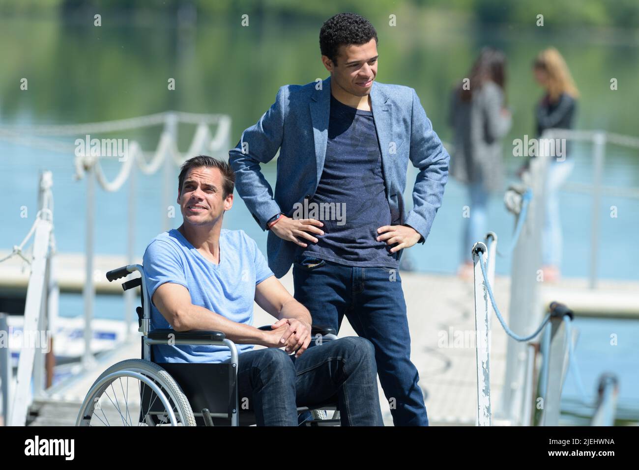 disabled person in a wheelchair talking to friend Stock Photo - Alamy