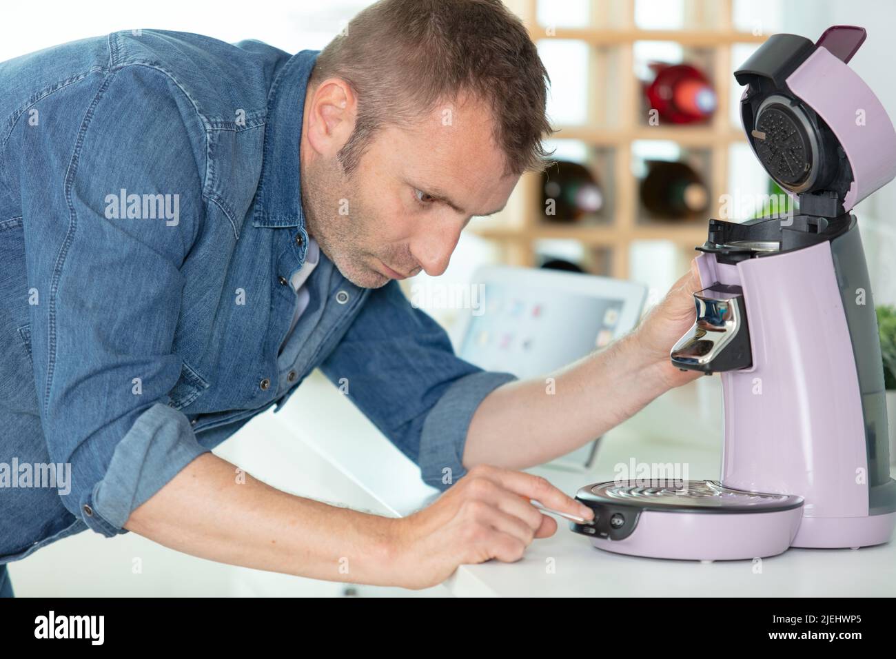 concentrated man renovating coffee machine Stock Photo - Alamy