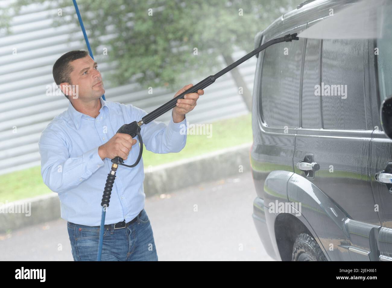 man pressure washing vehicle Stock Photo - Alamy