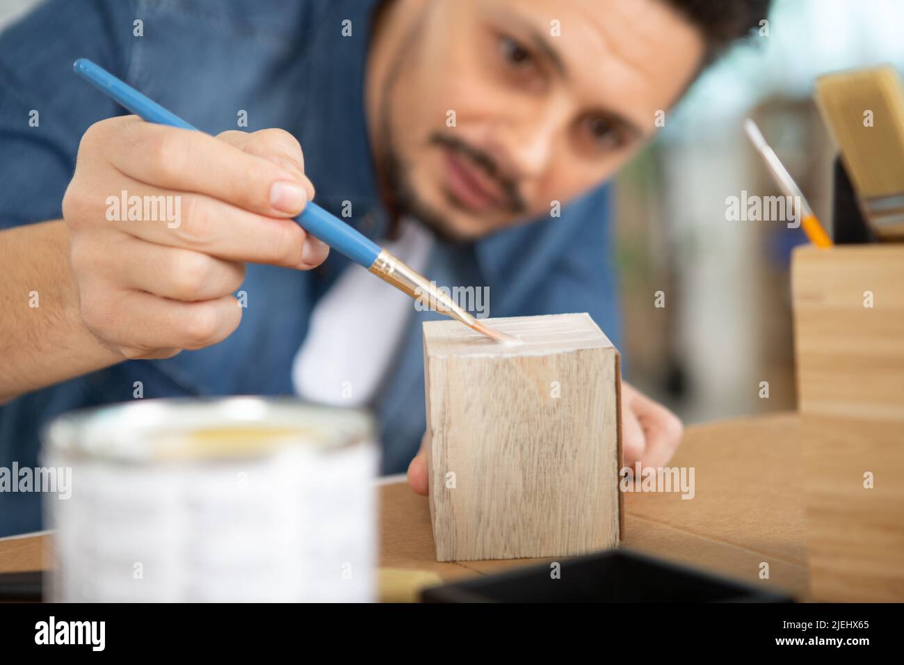 young man decorating pottery in class Stock Photo - Alamy