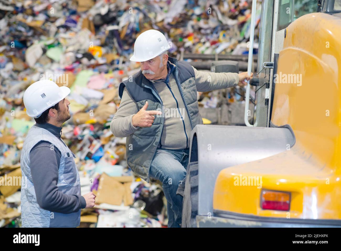 two workmen in recycling center Stock Photo - Alamy