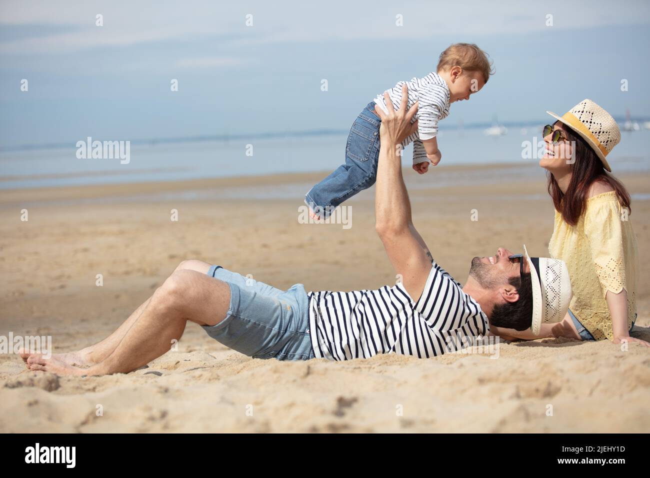 baby laughing while playing with his dad on the beach Stock Photo - Alamy