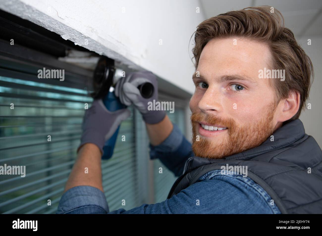 man grinding window surface with electric grinder Stock Photo - Alamy