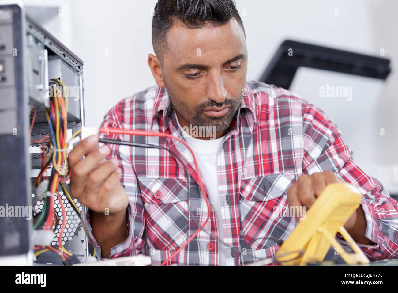technician using voltage meter for voltage measurement in computer ...