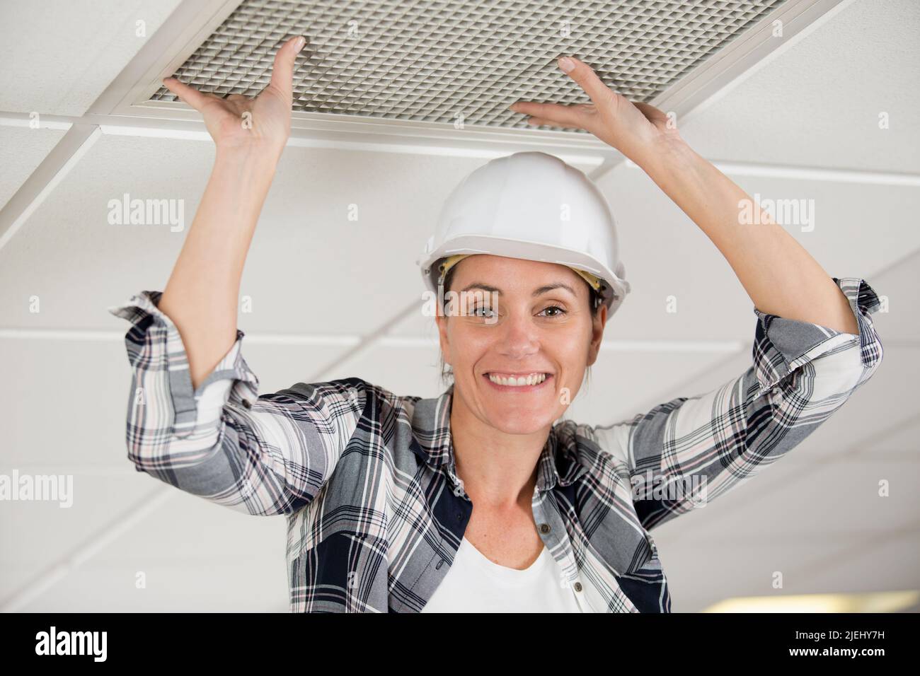 woman in builder uniform installing suspended ceiling Stock Photo - Alamy
