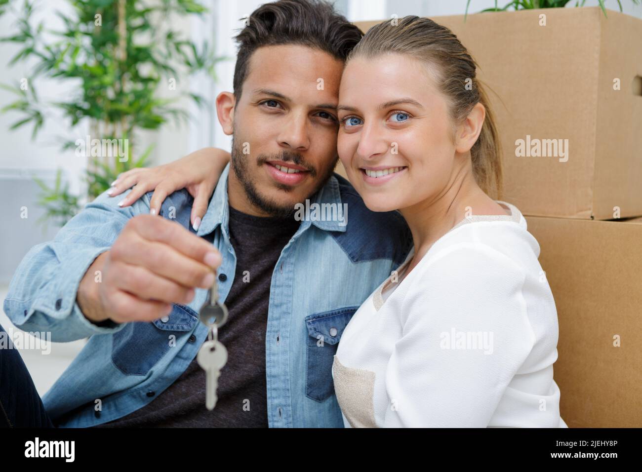 portrait of young couple holding keys by stacked boxes Stock Photo - Alamy