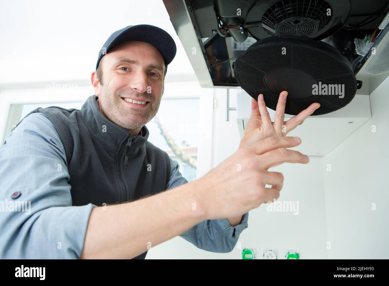 portrait of man changing filter in kitchen extractor hood Stock Photo ...