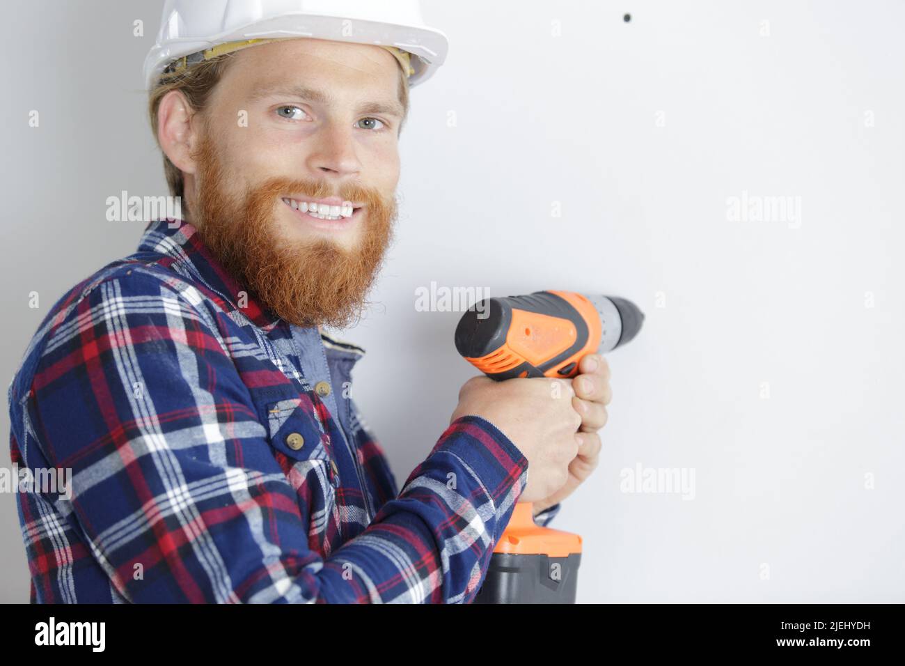 positive construction worker with power drill Stock Photo - Alamy