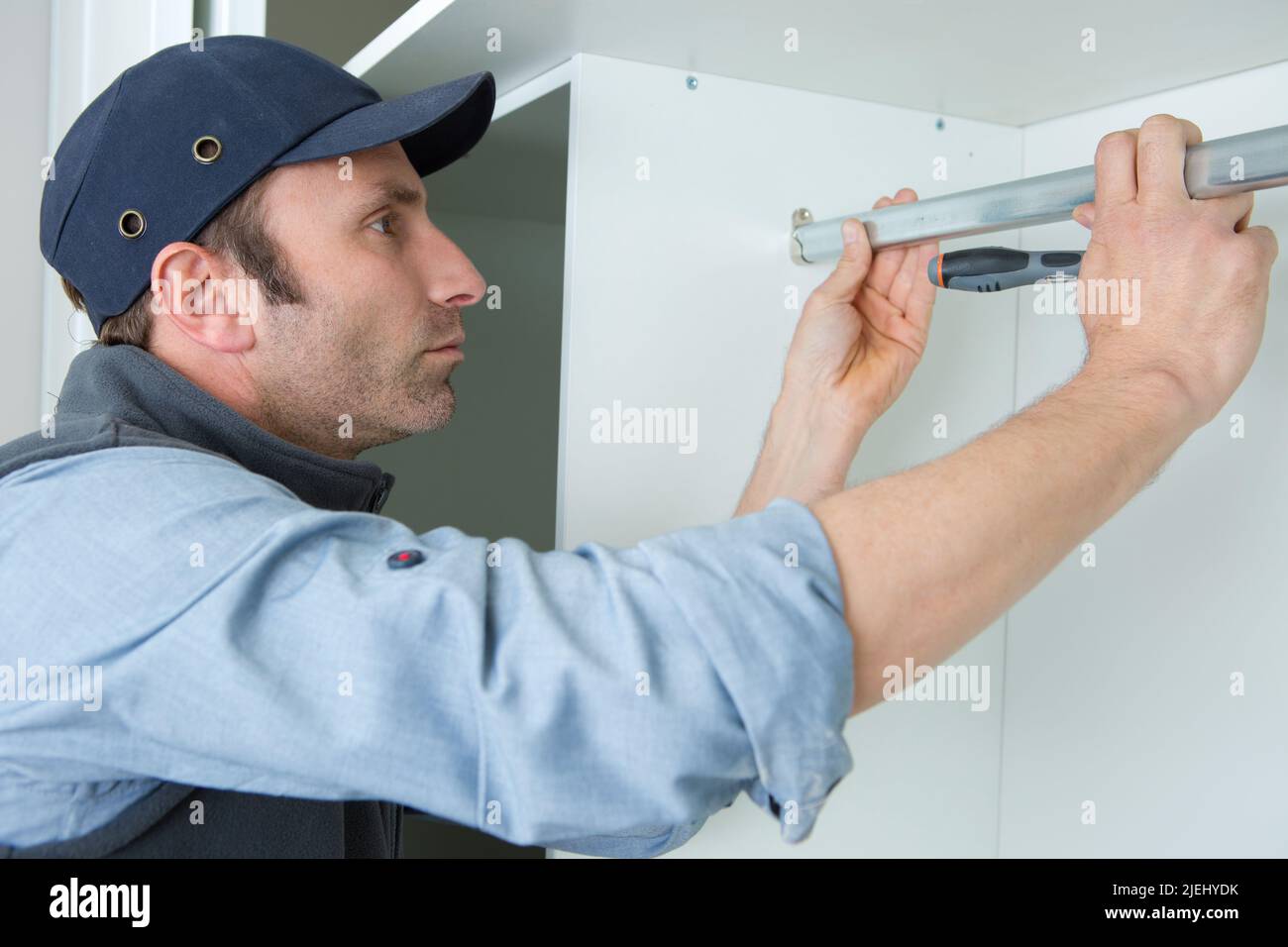 man assembling wardrobe furniture in the apartment Stock Photo - Alamy