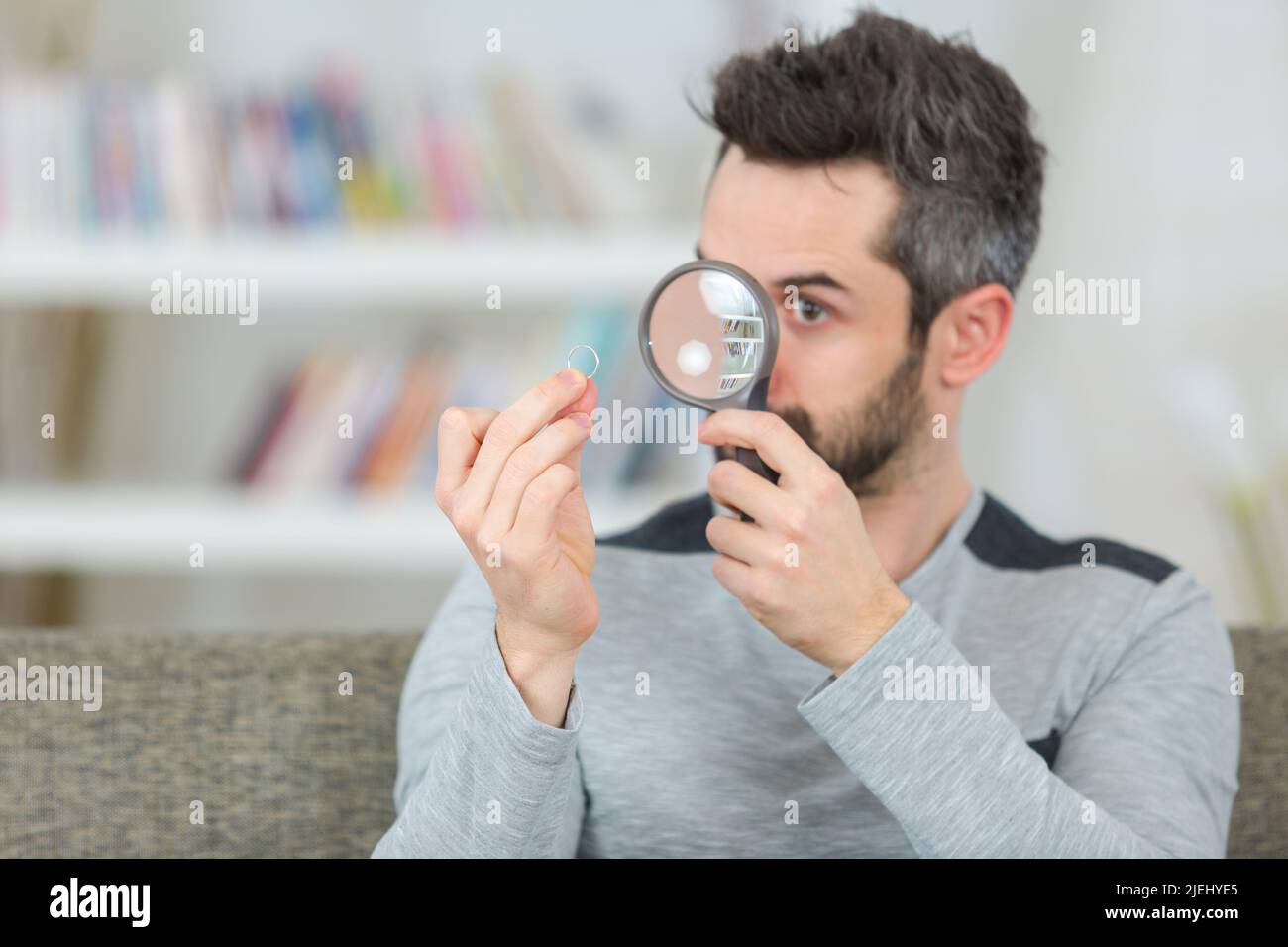 man looking through magnifying glass Stock Photo - Alamy