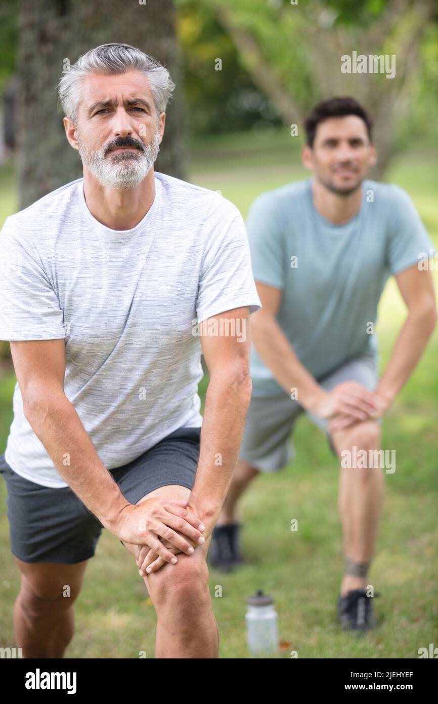 full length portrait of a handsome men stretching legs outdoors Stock ...